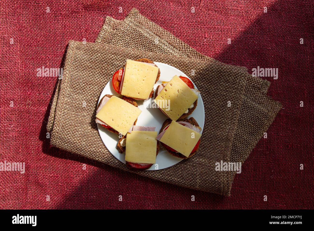 Top view of several self-made sandwiches on white plate lie on rustic ...