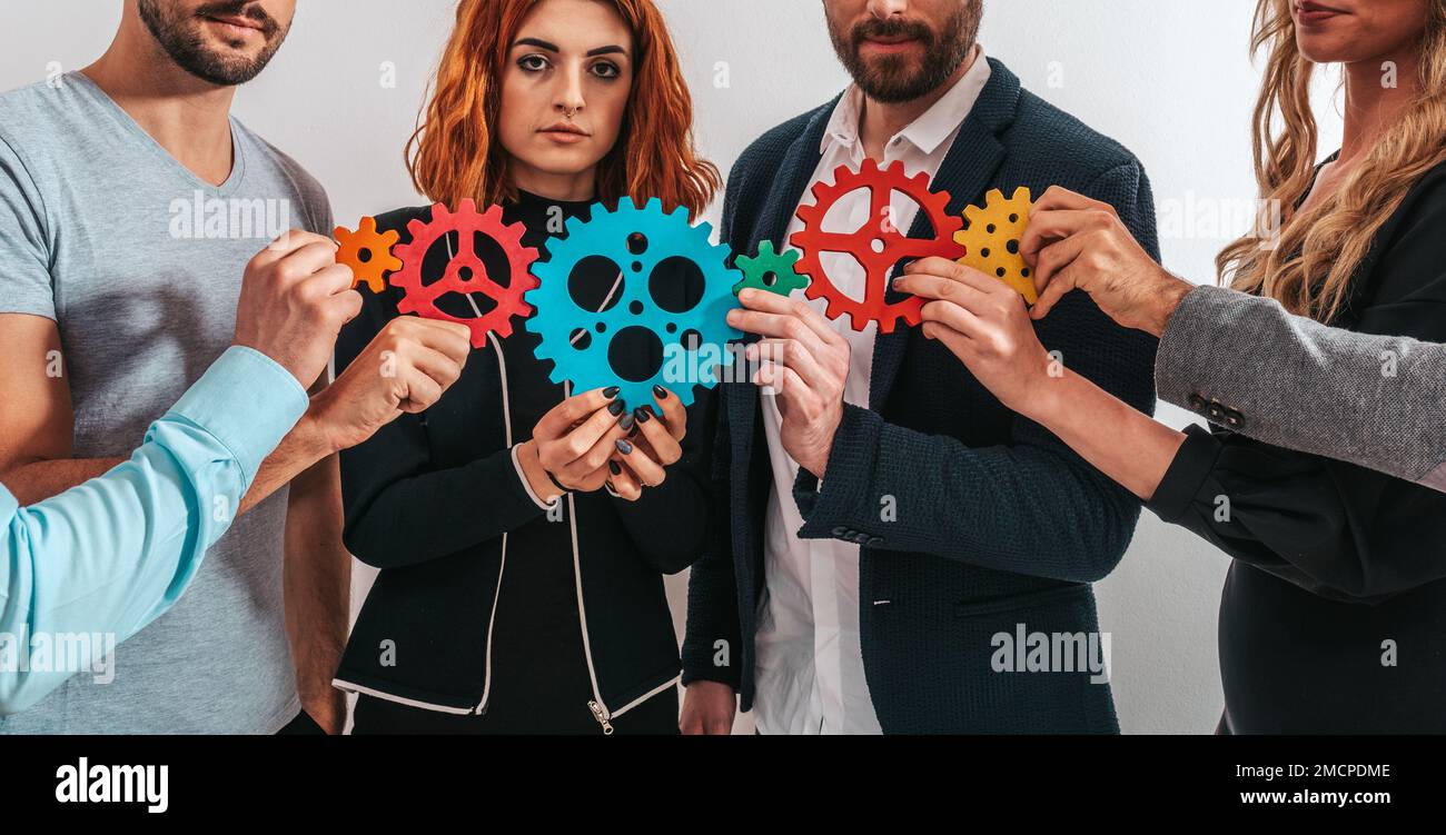 Teamwork of businesspeople work together and combine pieces of gears as ...