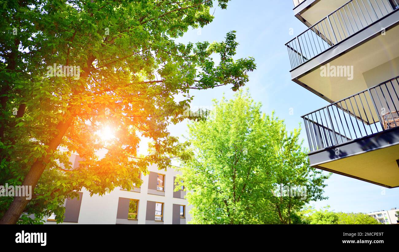 Urban residential architecture close to nature. Green trees near ...