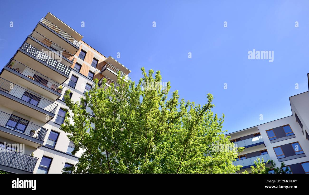 Urban residential architecture close to nature. Green trees near ...
