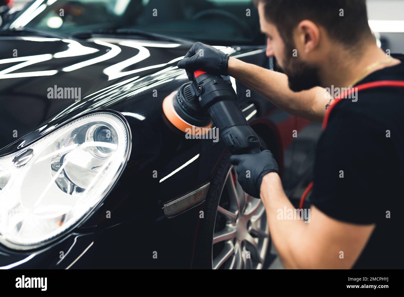 Passion for cars. Car detailing process. Male detailing studio worker ...