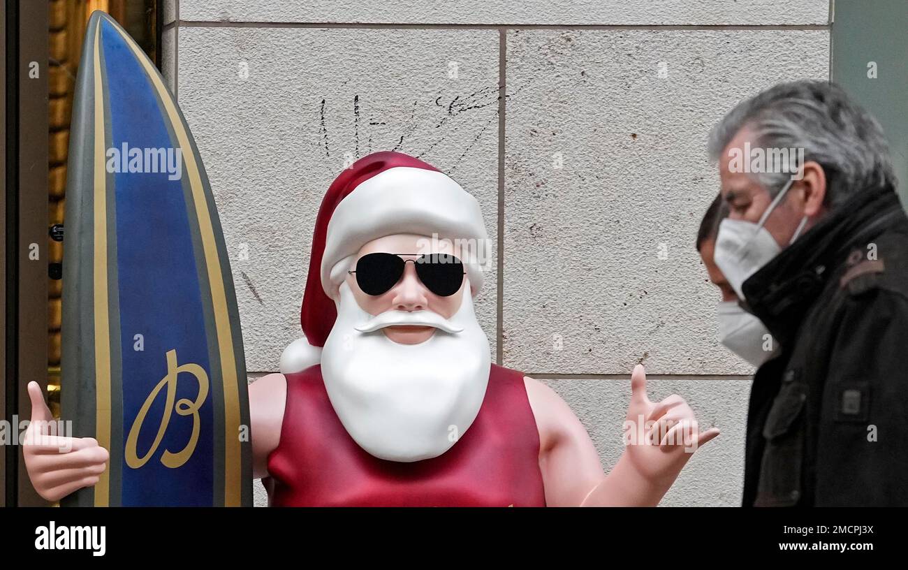 A man wears a face mask due to the coronavirus pandemic as he walks ...