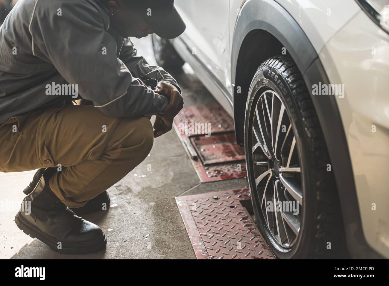 Mechanic checking geometry and suspension of a car wheel using ...