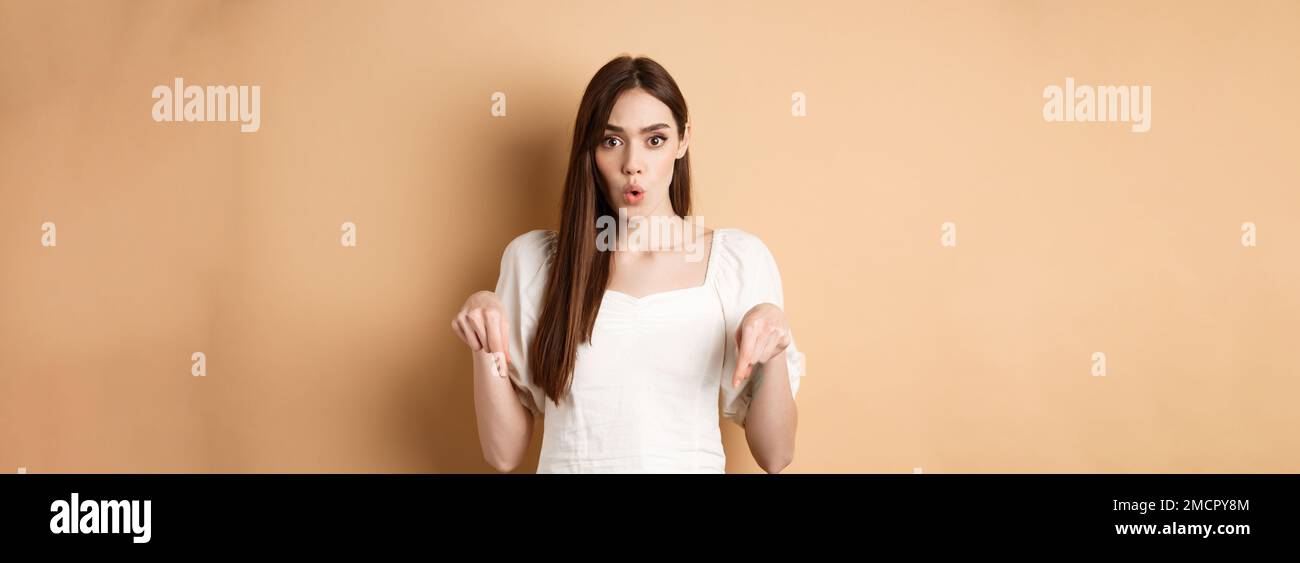 Wow amazing. Impressed young woman look astonished by product, pointing ...