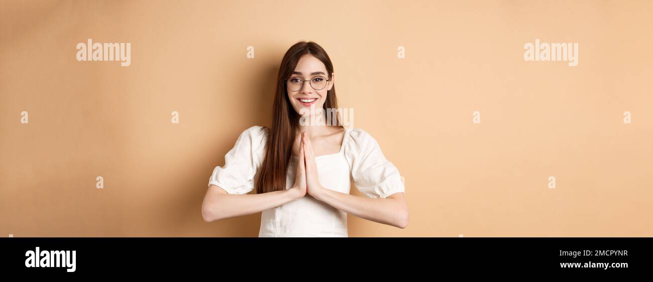 Smiling girl in glasses say thank you, show namaste gesture, express ...