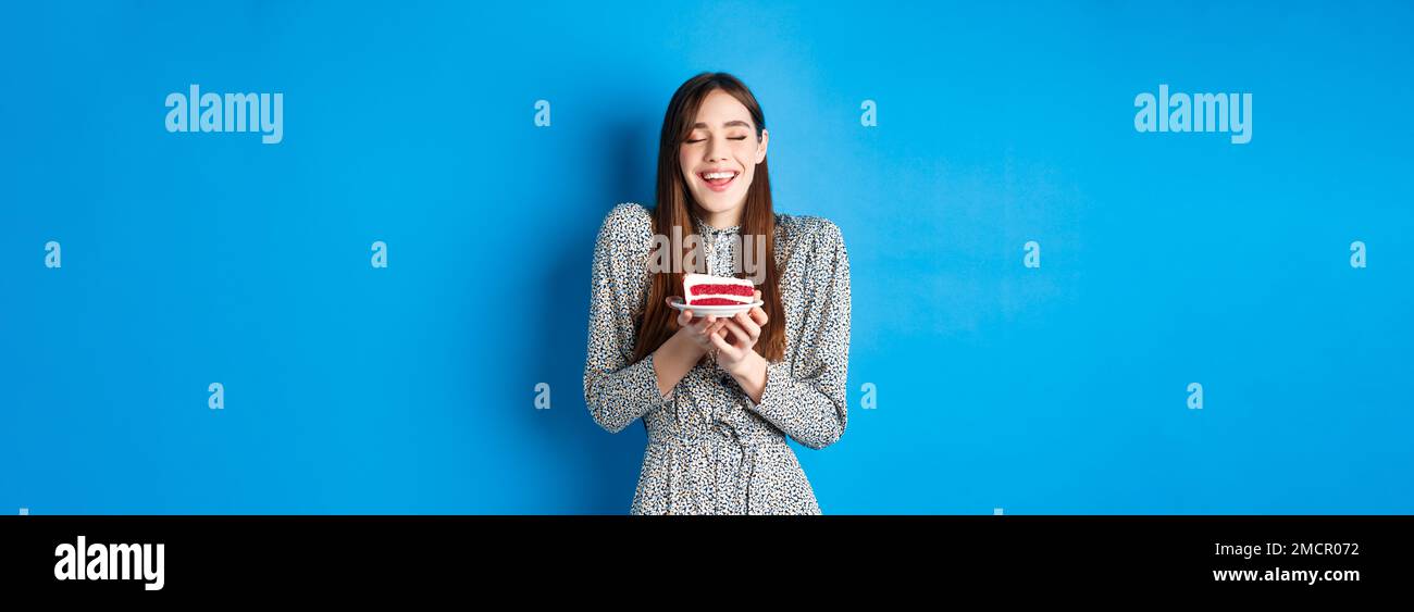 Dreamy birthday girl making wish with closed eyes and happy smile ...