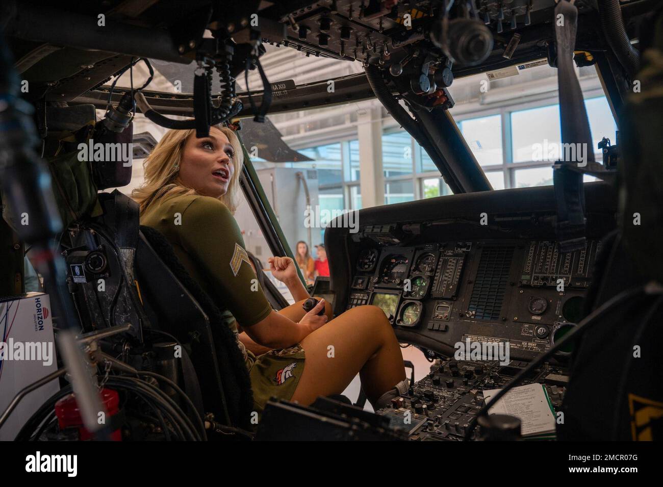 A Denver Broncos cheerleader sits inside a UH-60 Black Hawk helicopter ...