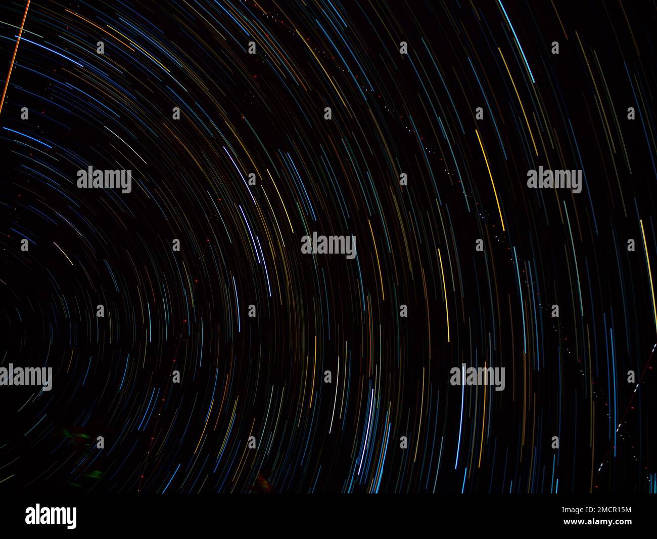 A long exposure of the night sky showing star trails interrupted by the ...