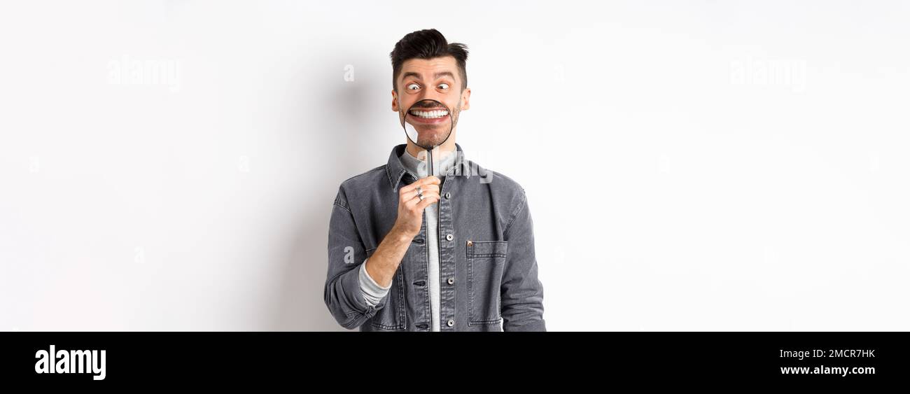 Handsome positive guy showing white perfect smile with magnifying glass ...