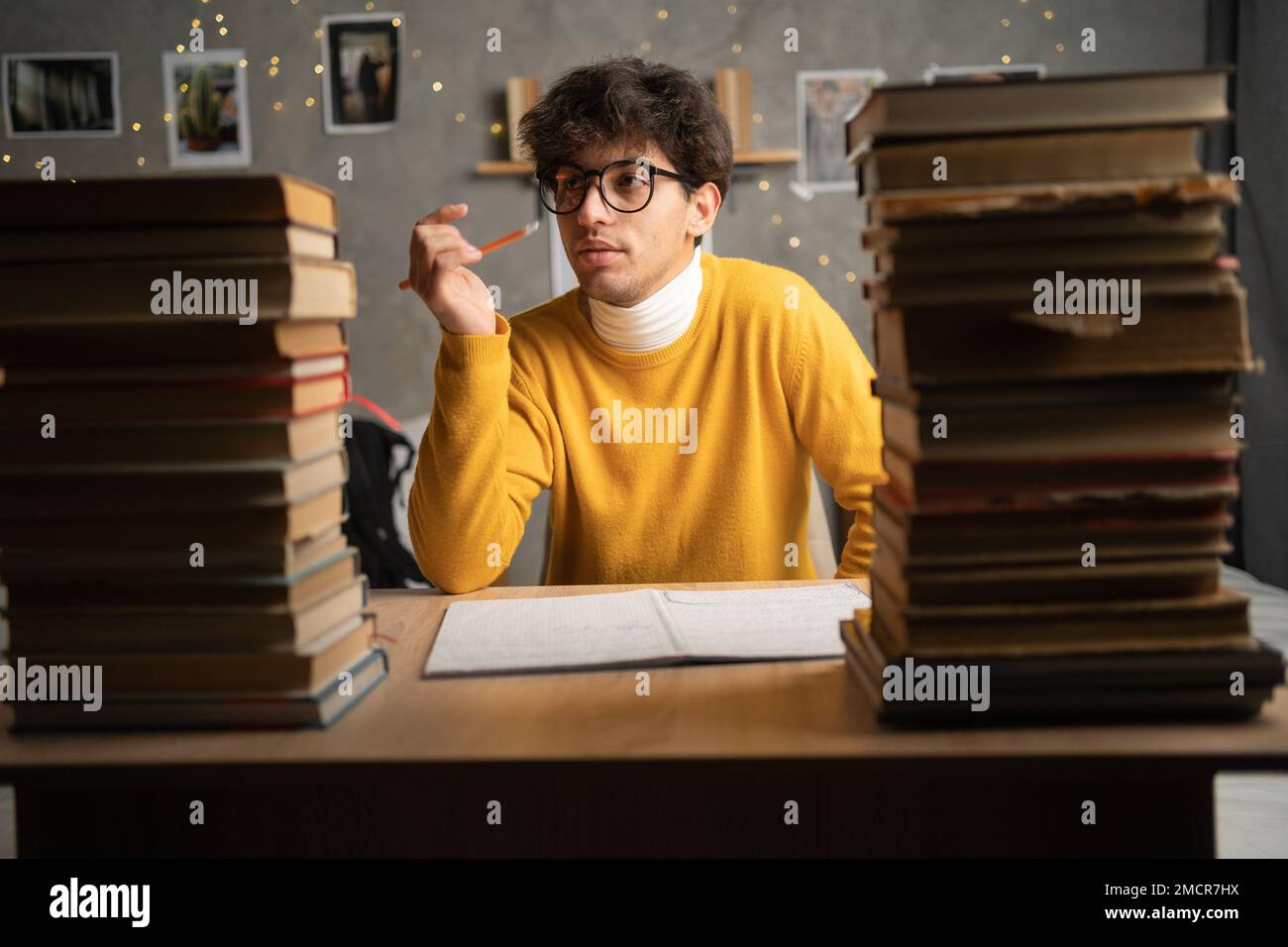 Library study. Thinking dreaming thoughtful young man with books in ...