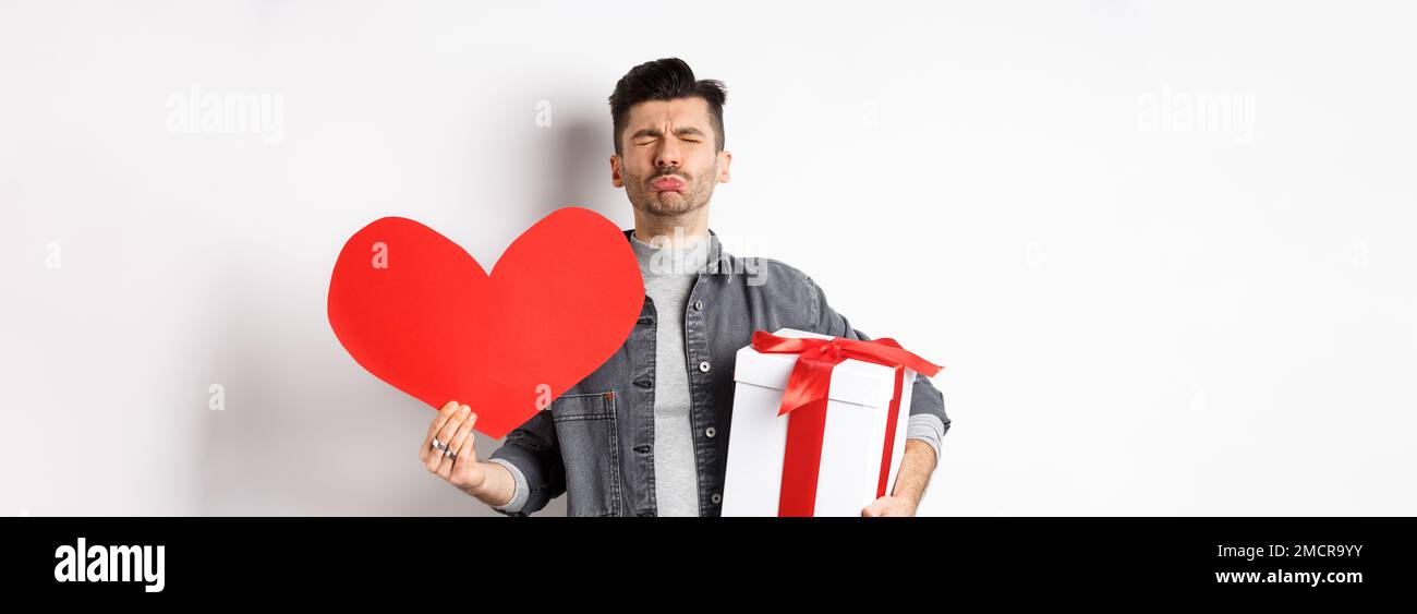 Sad and heartbroken man being rejected, crying and holding red heart ...