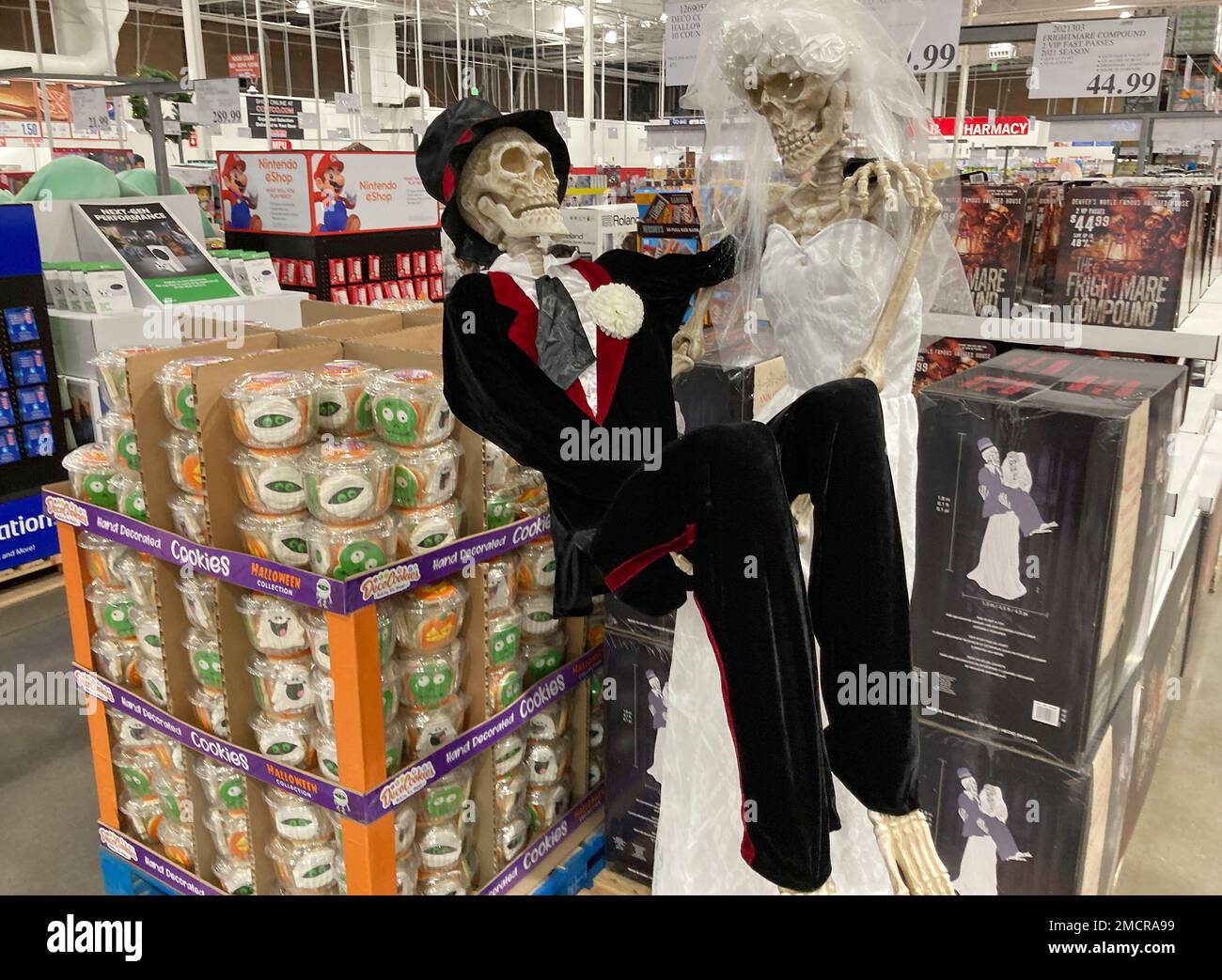 Skeltons dressed for Halloween stand near goods for sale in a Costco ...