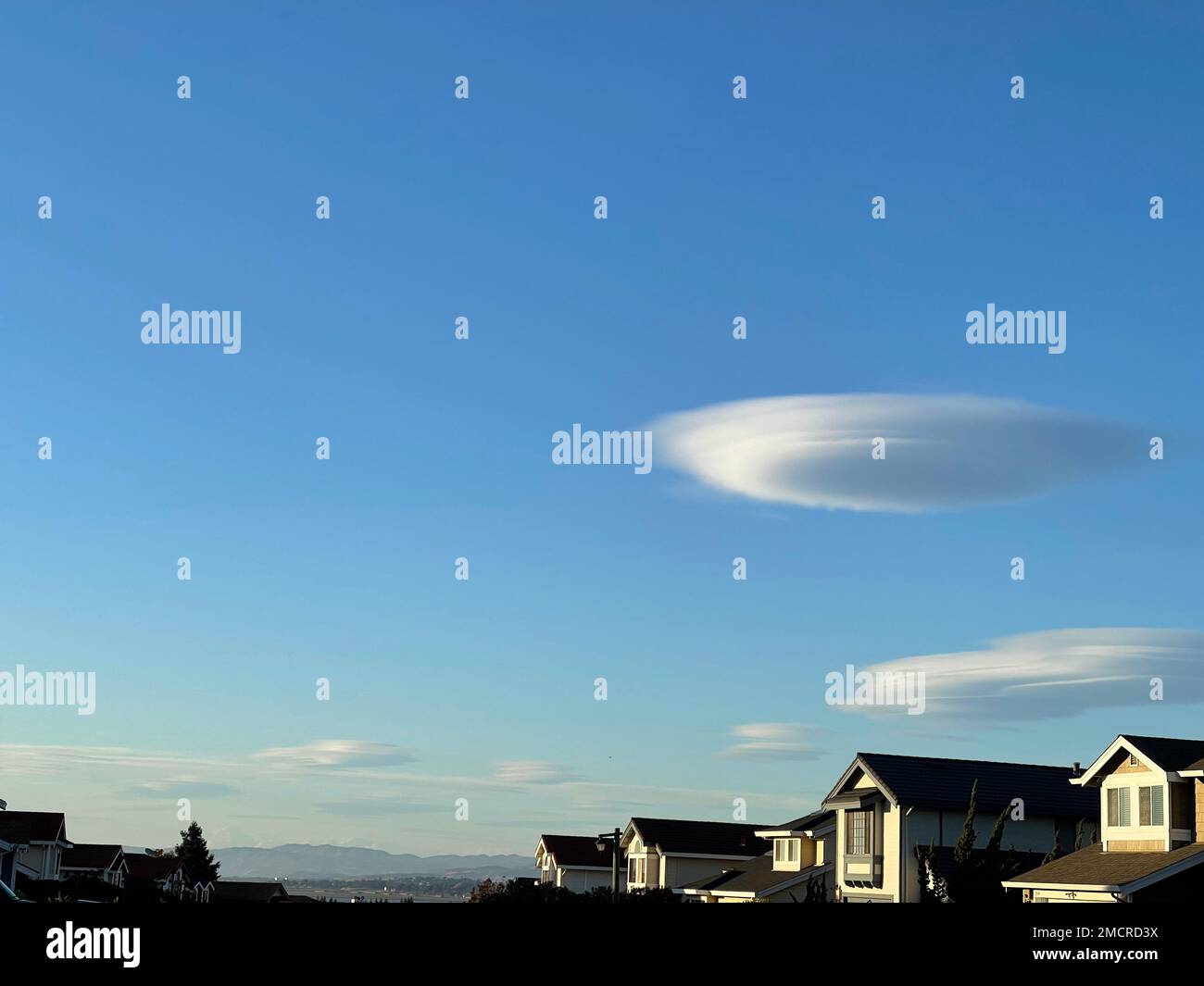 A scenic view of UFO-shaped clouds floating in the blue sky above ...
