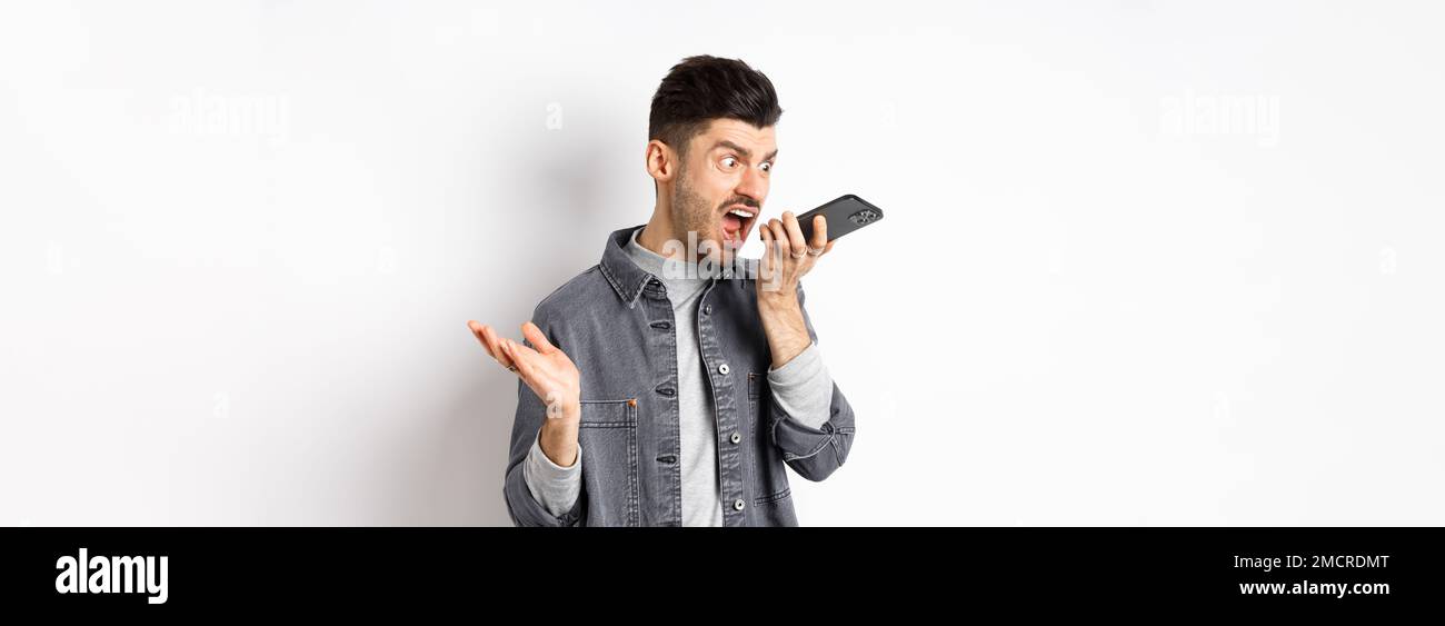 Angry guy shouting at speakerphone, scream on mobile phone, leaving ...