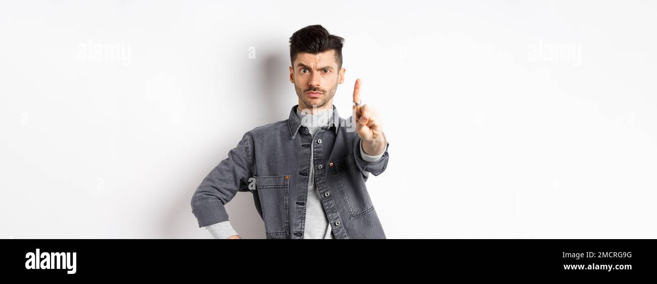 Stop right here. Serious man scolding, shaking finger and frowning ...