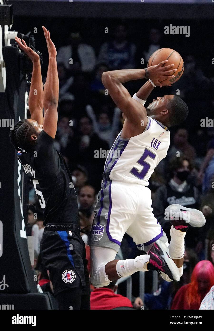 Sacramento Kings guard De'Aaron Fox, right, shoots as Los Angeles ...