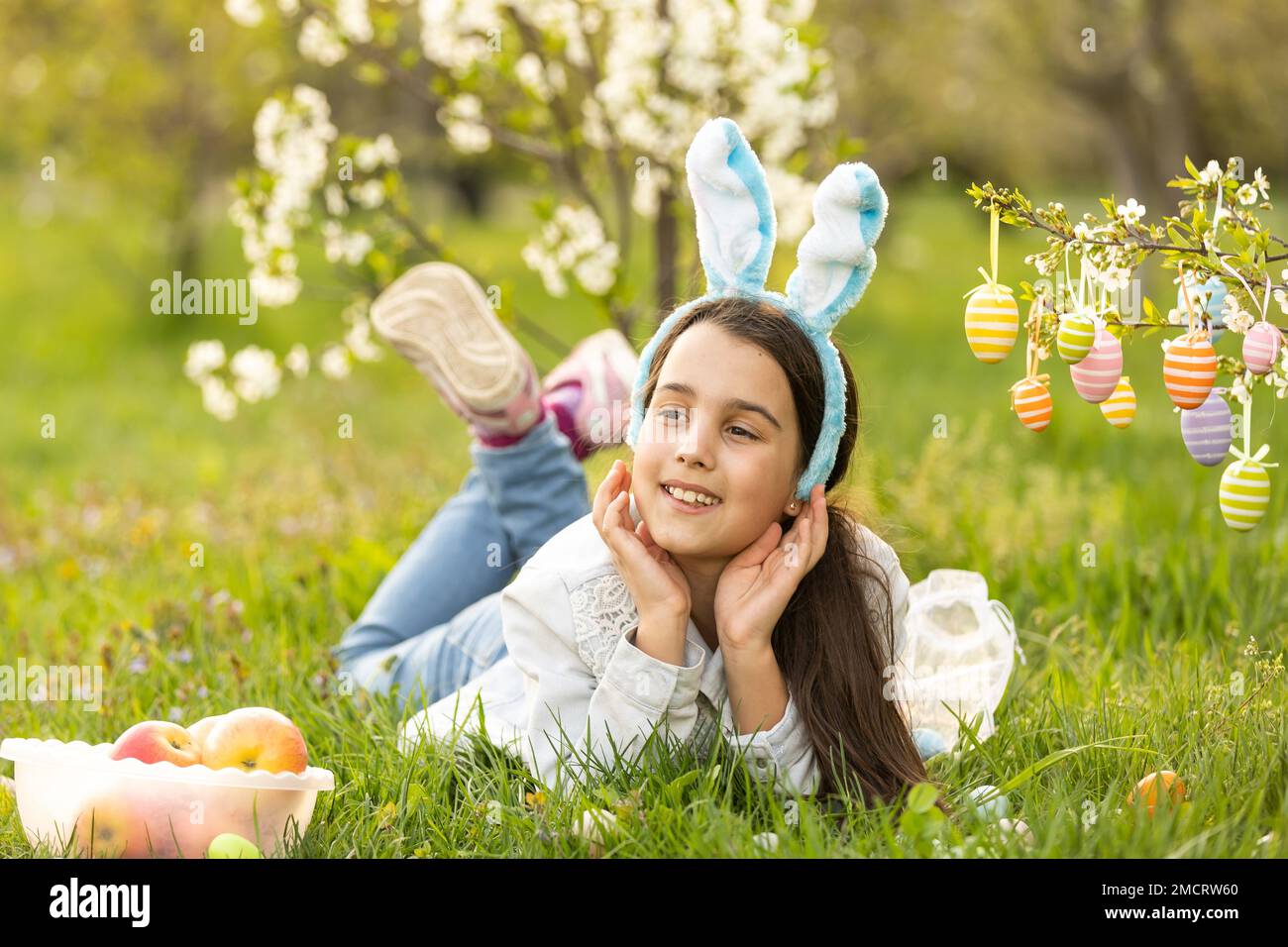 Adorable little girl on Easter holiday sitting on the grass Stock Photo ...