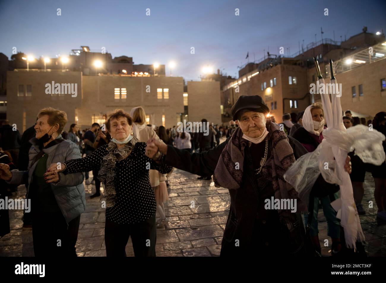 Holocaust survivors dance during a Hanukkah menorah lighting ceremony ...