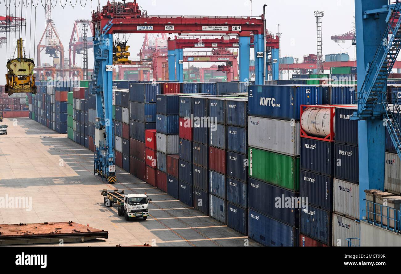 A truck drives past stacks of containers at an Indonesia Port ...
