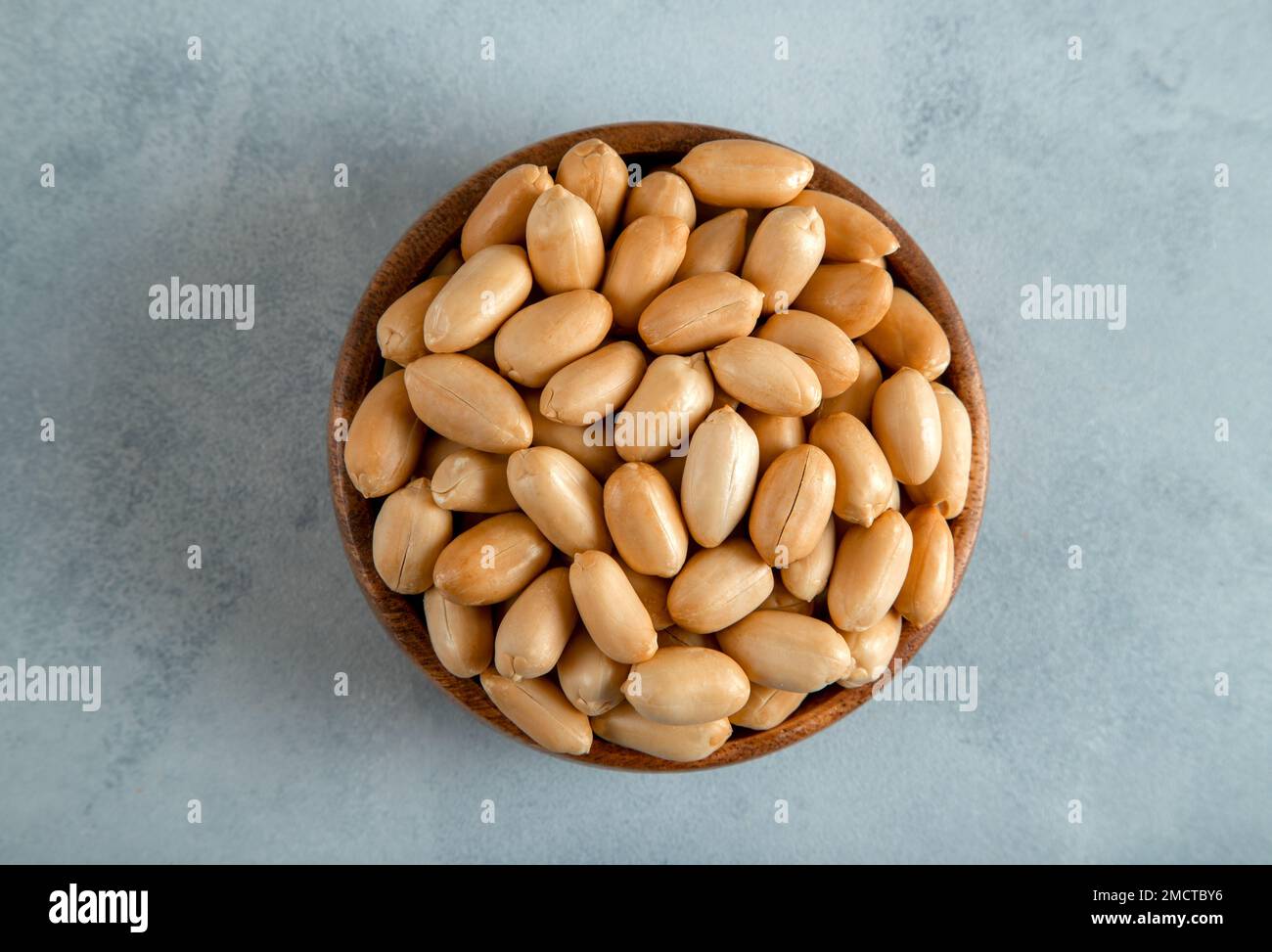 Bowl full of roasted peeled peanuts on bright background Stock Photo ...