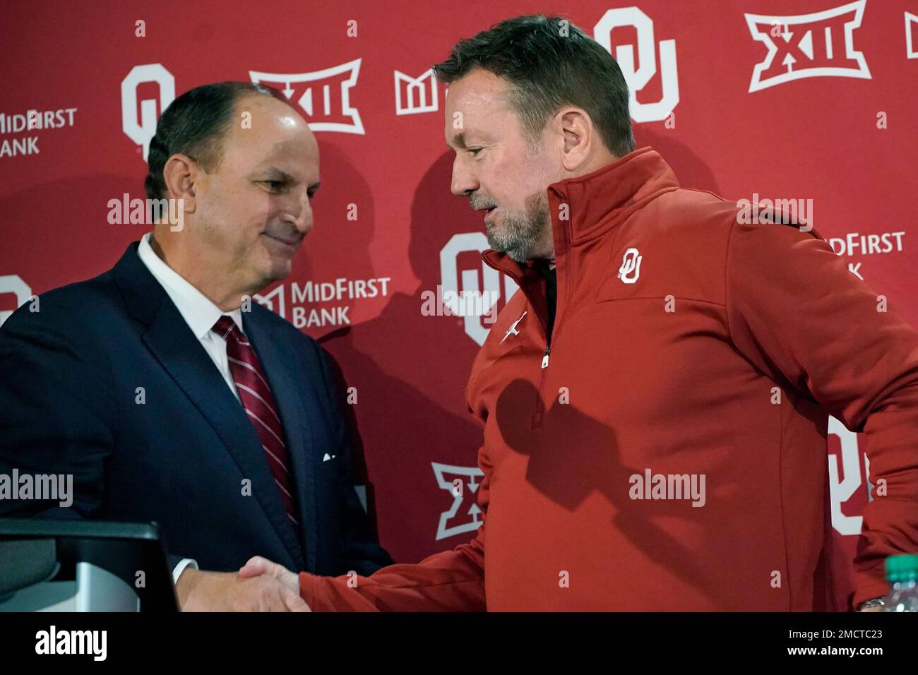 Oklahoma interim head football coach Bob Stoops, right, shakes hands ...
