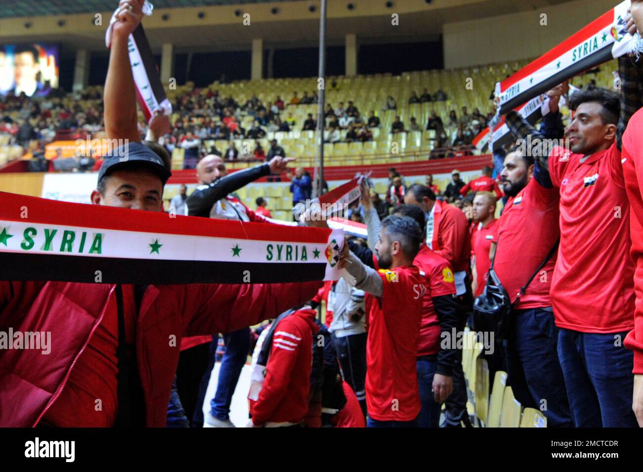 Syrian basketball fans hold their national flags as they cheer during ...