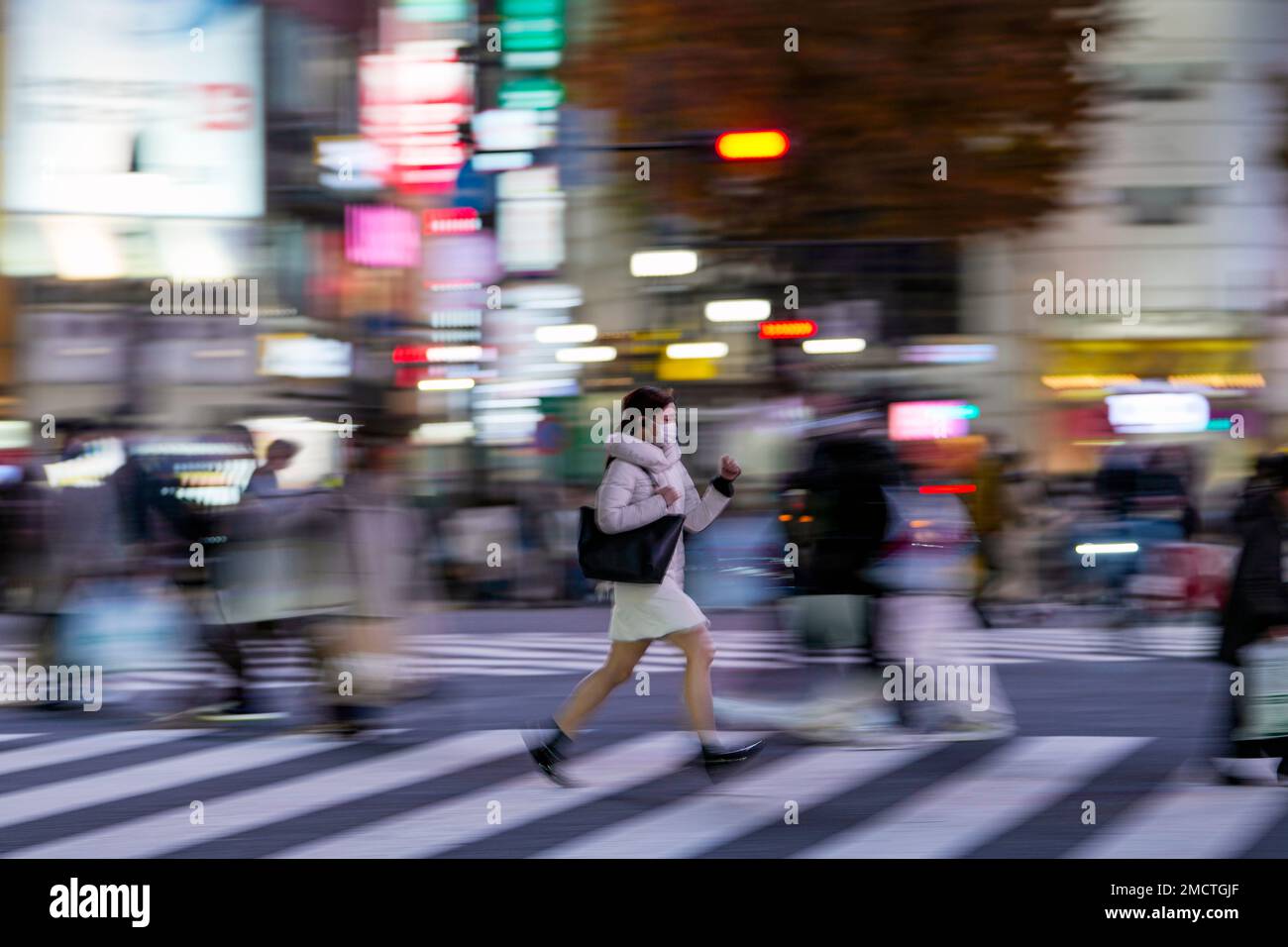 People wearing protective masks walk around the famed Shibuya scramble ...