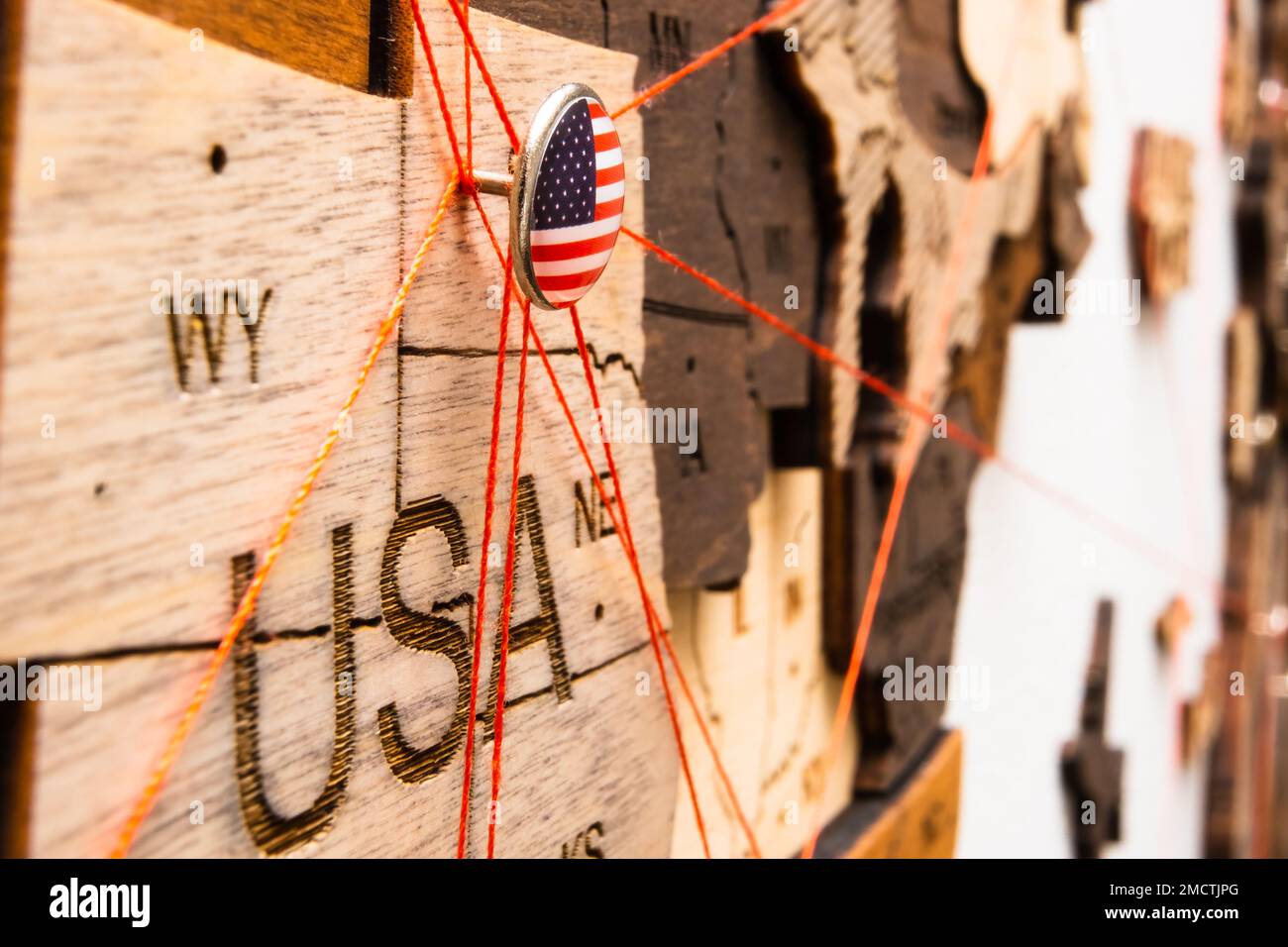 USA flag on the pushpin with red thread showed the paths of movement or ...