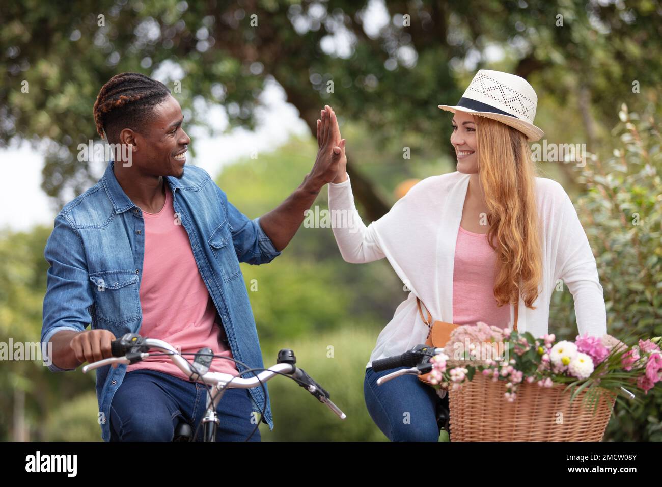 happy young couple with bicycles at country making high five Stock ...