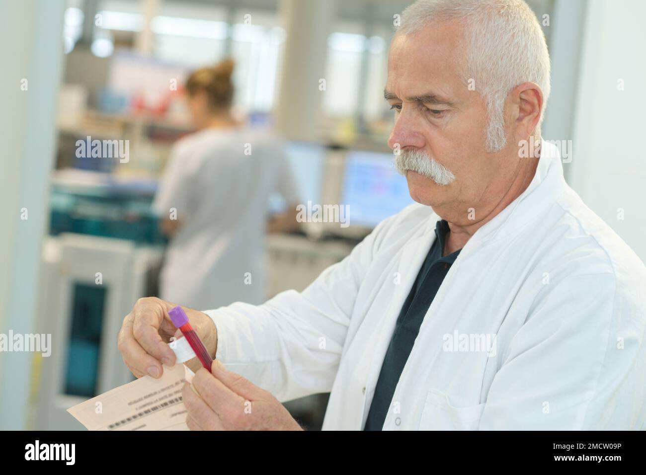 elderly doctor holding blood test Stock Photo - Alamy