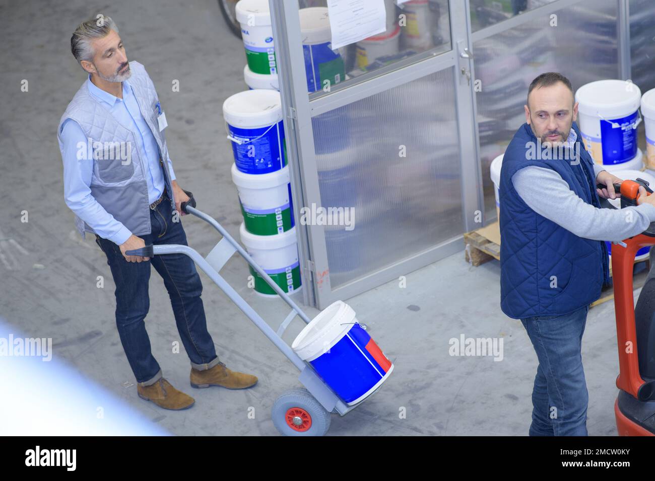 painter with white overall carrying a paint bucket Stock Photo - Alamy