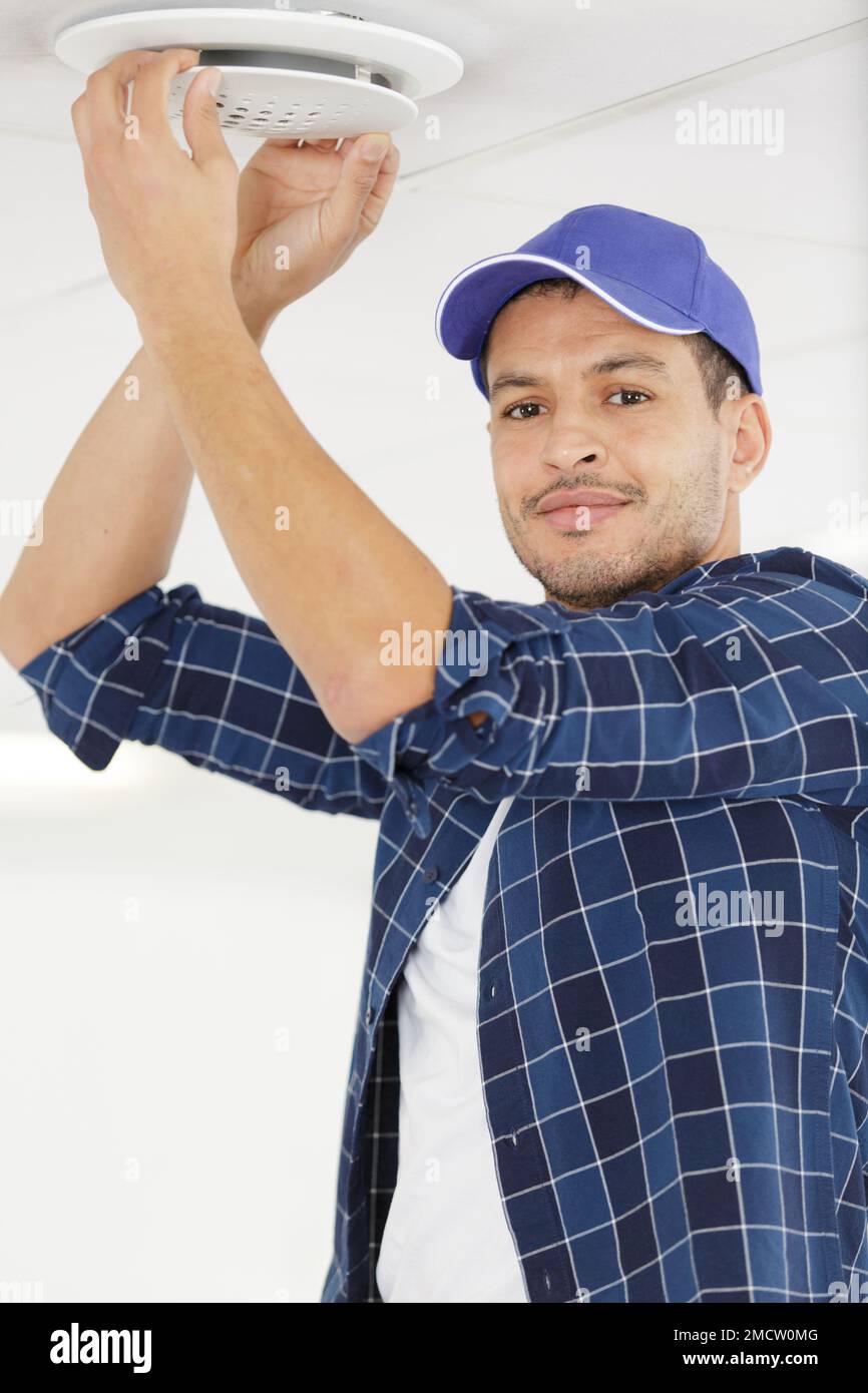 friendly contractor fitting ceiling vent Stock Photo - Alamy
