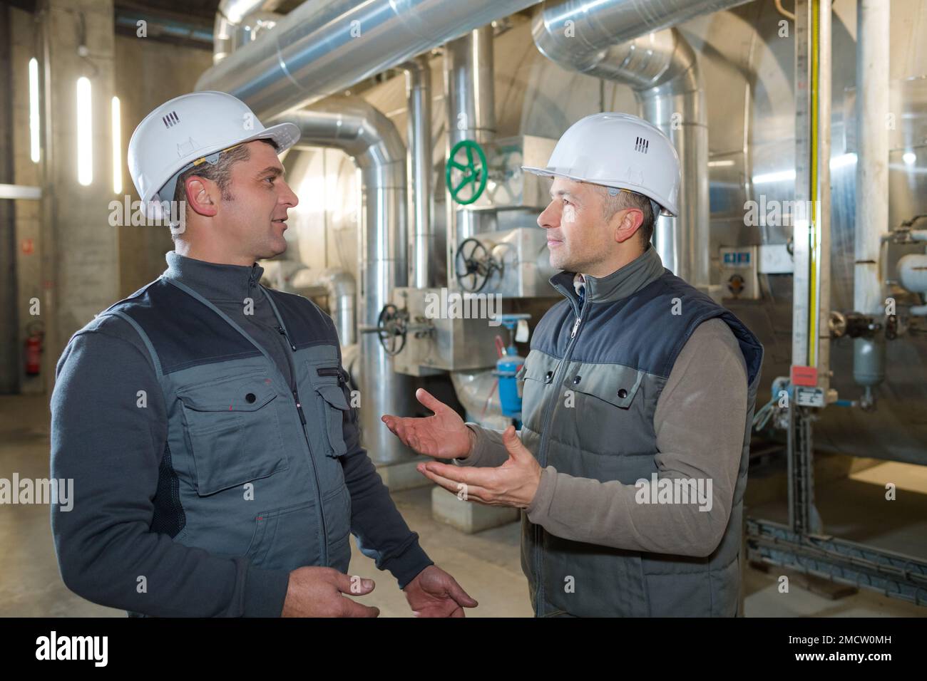 men discussing something in factory Stock Photo - Alamy