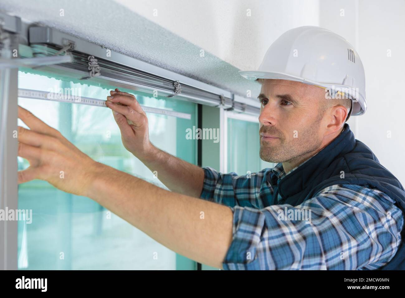 construction worker putting sealing foam tape on window in house Stock ...