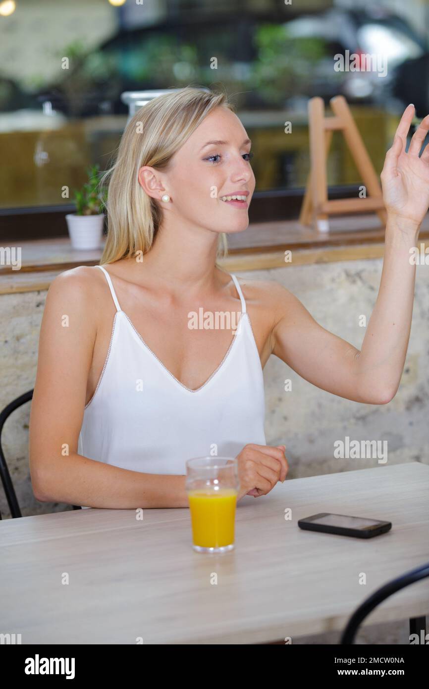 elegant woman calling for waiter Stock Photo - Alamy