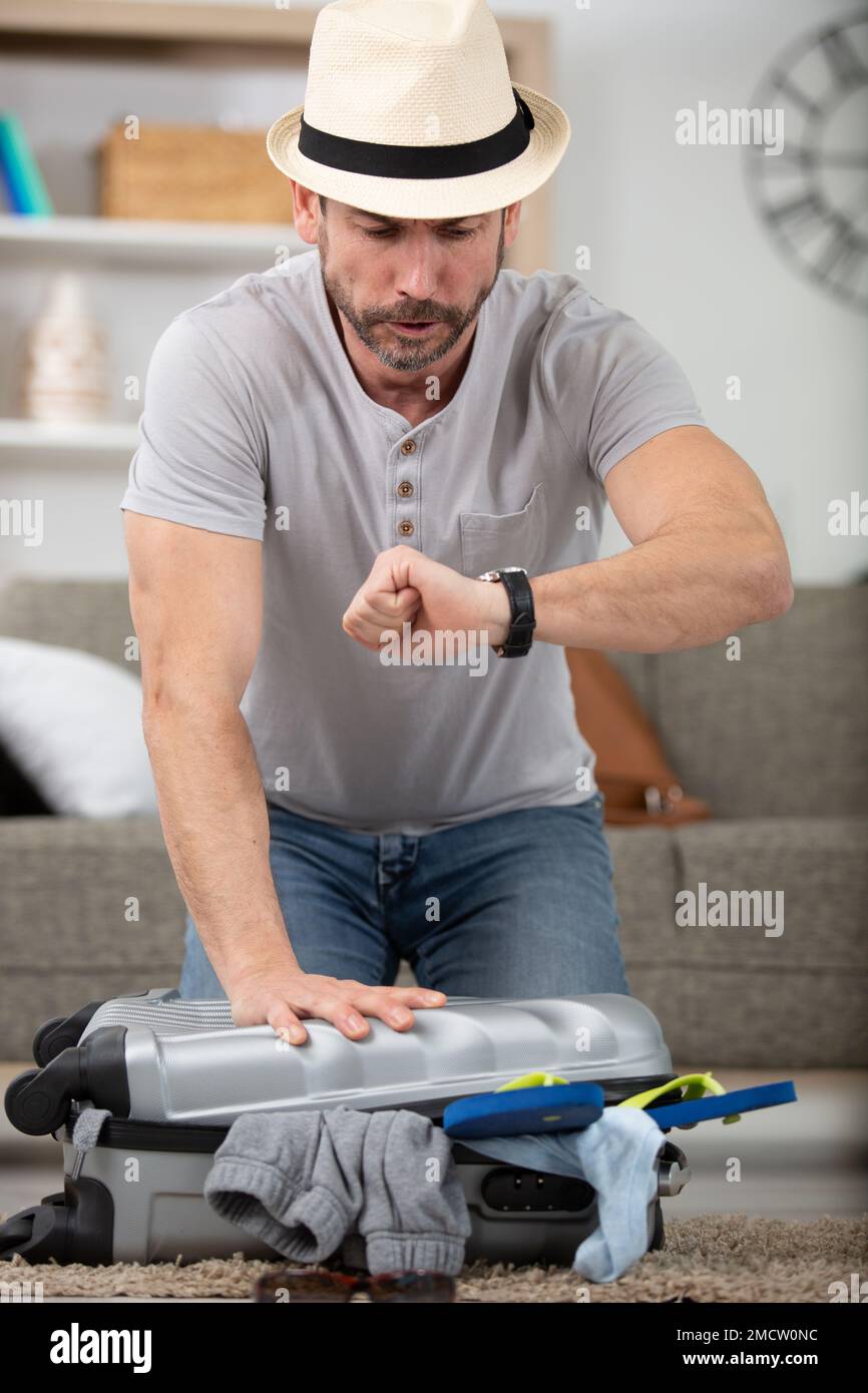 stressed man packing suitcase in a hurry Stock Photo - Alamy