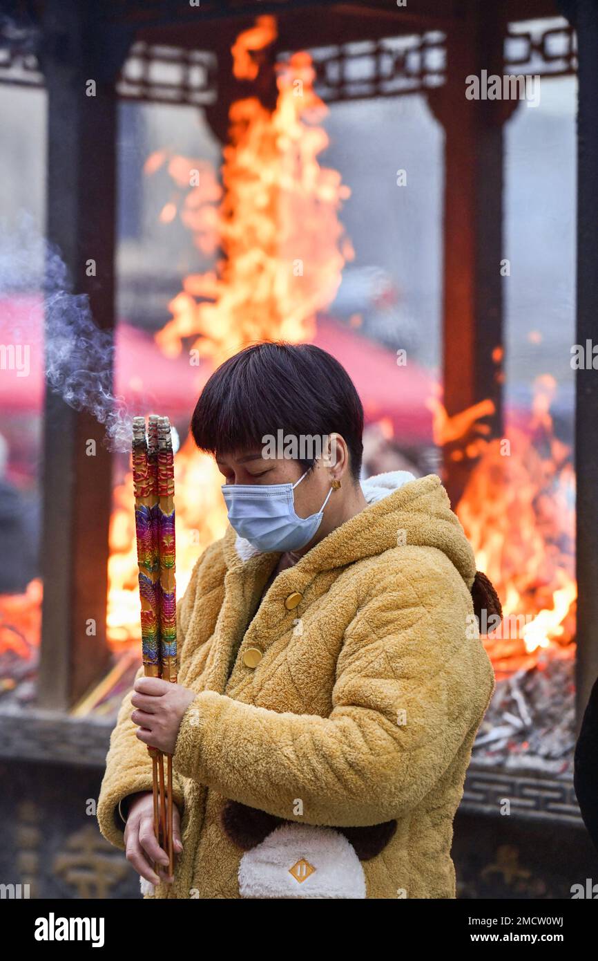 A woman burns incense and prays for good luck at the Zifu Temple in ...
