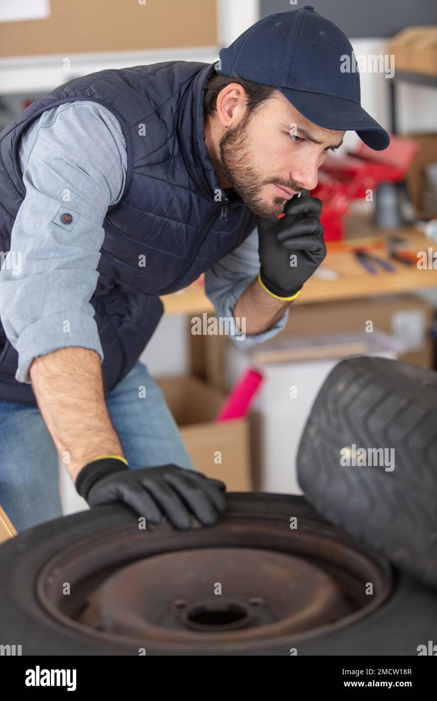 mechanic working with used wheel rims Stock Photo - Alamy