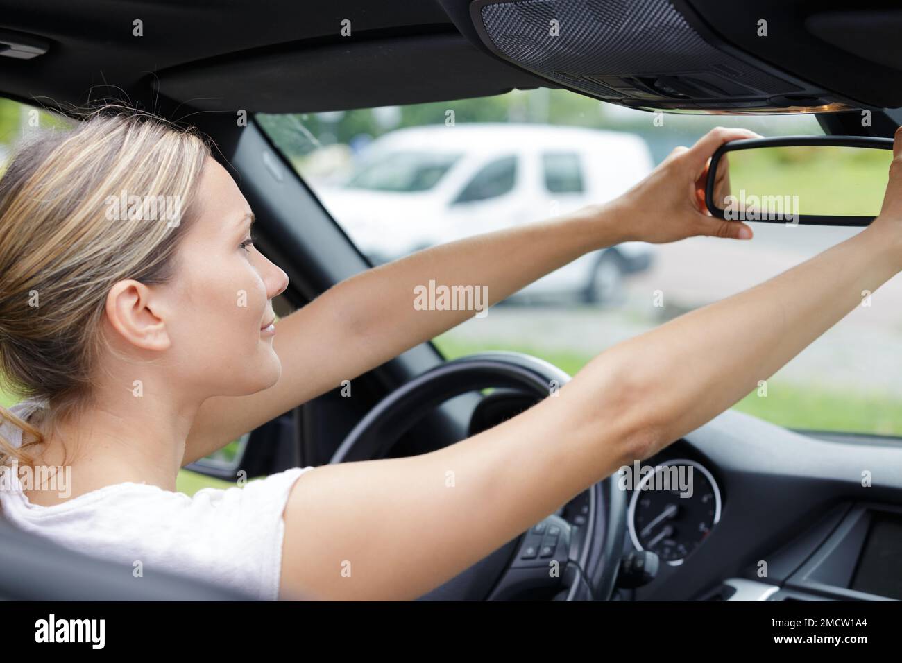 woman adjusting the rear view mirror in her car Stock Photo - Alamy