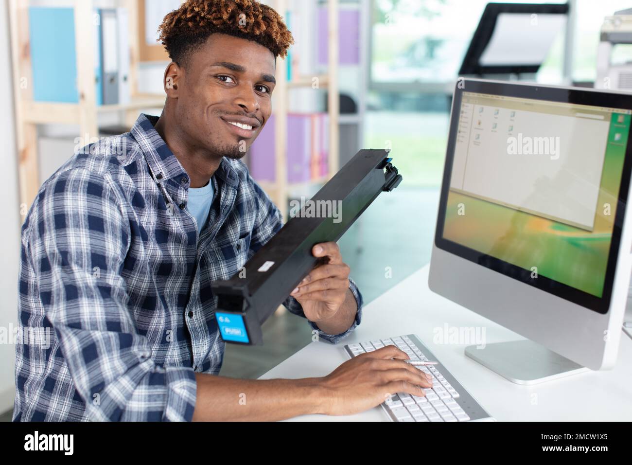 happy young man works on his computer at the office Stock Photo - Alamy