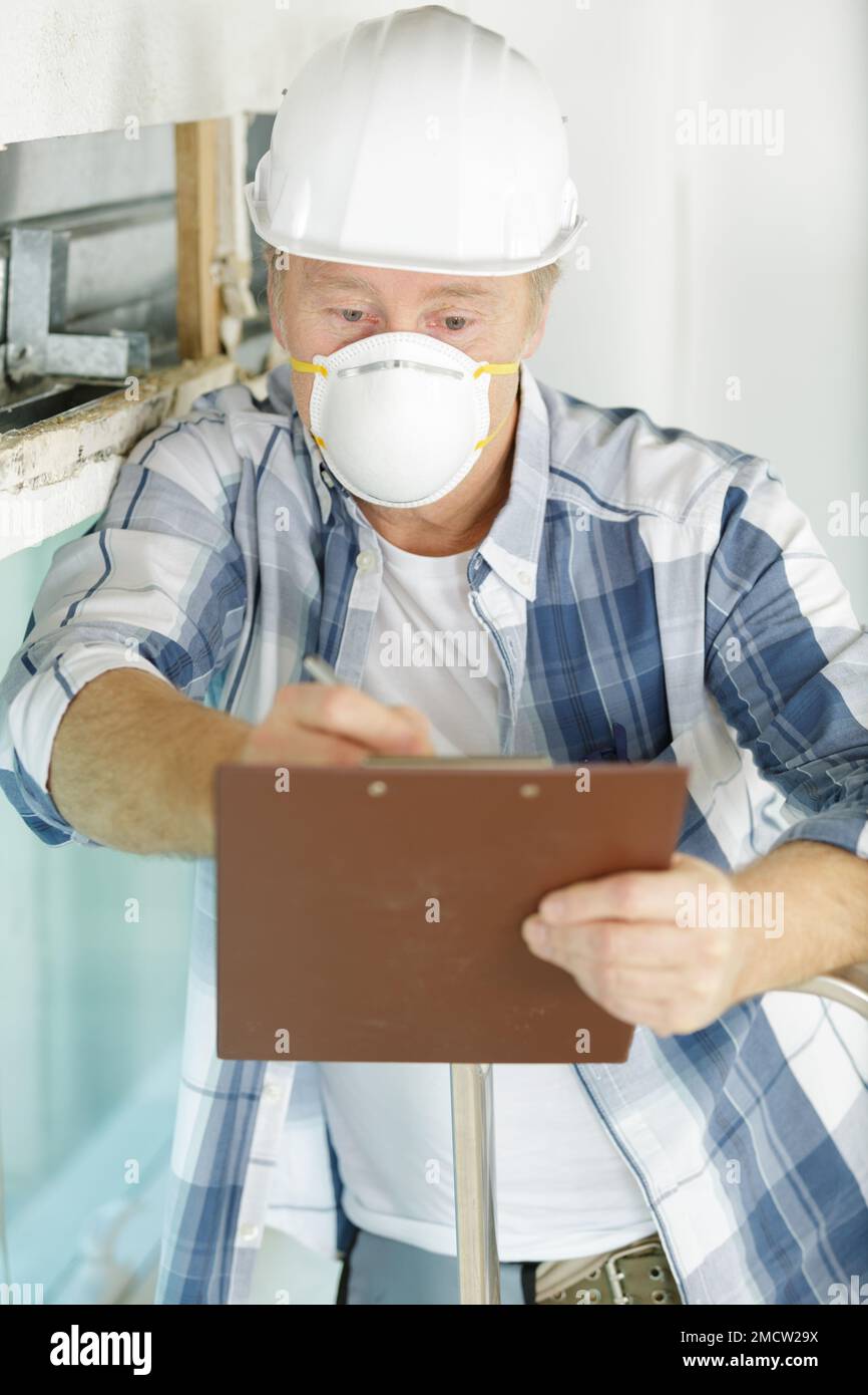 blue collar worker writing on clipboard Stock Photo - Alamy