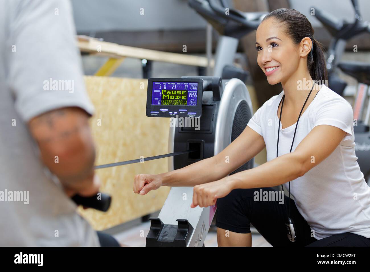 personal trainer demonstrating technique for gym equipment Stock Photo ...
