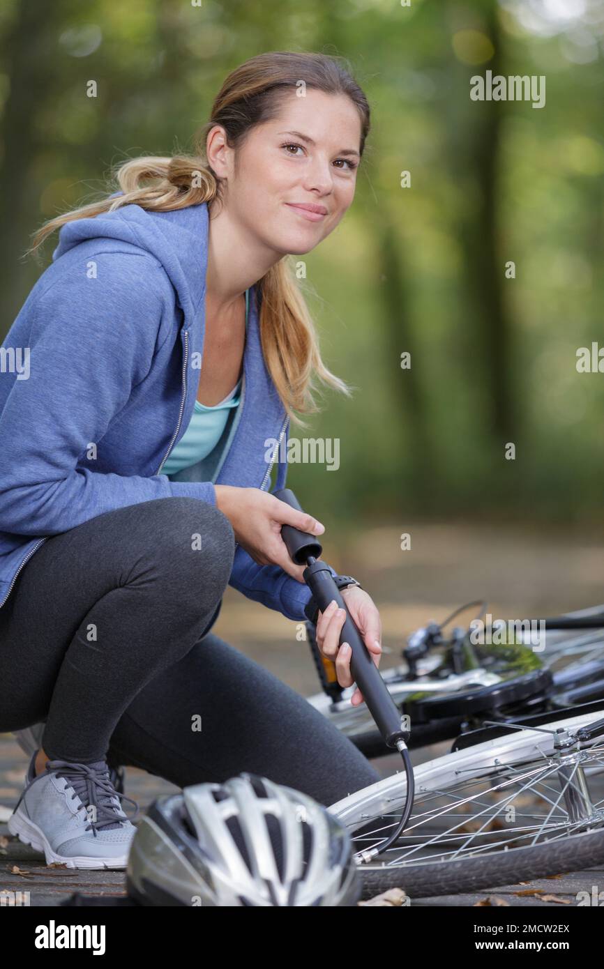 woman inflating bicycle tyre with pump Stock Photo - Alamy