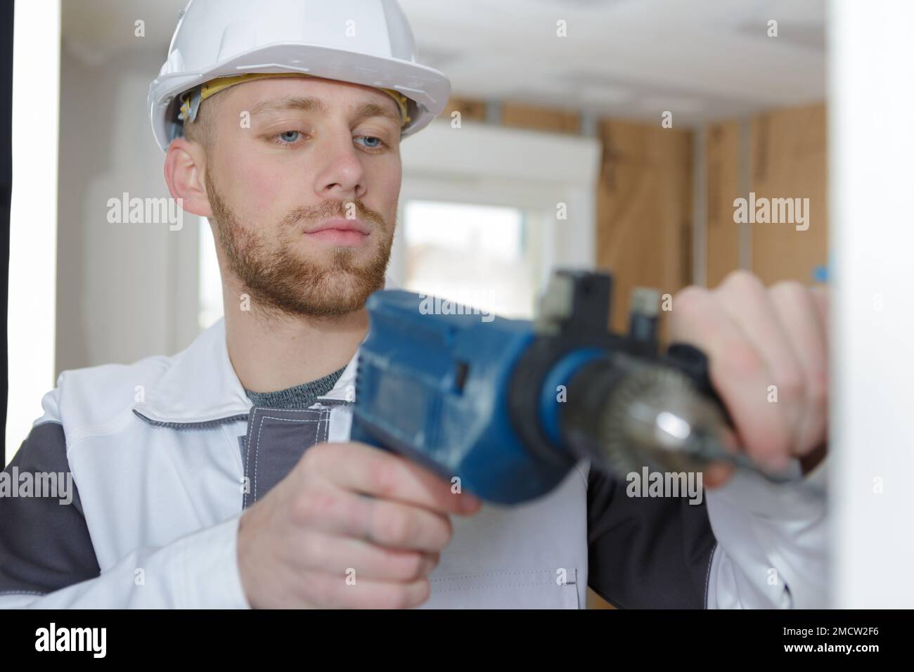 man drilling the wall with drill perforator Stock Photo - Alamy