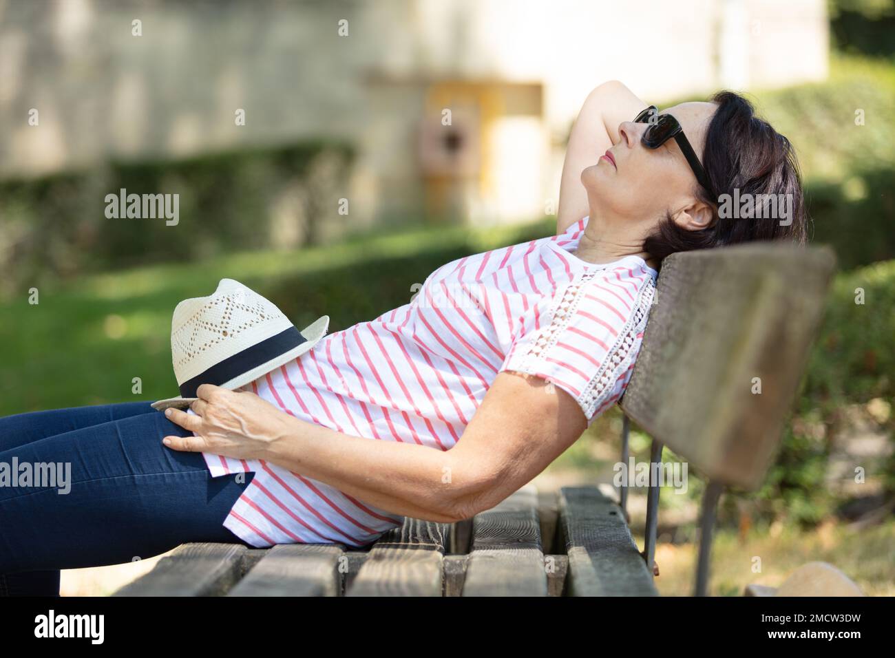 sleppy senior woman relaxing on park bench Stock Photo - Alamy
