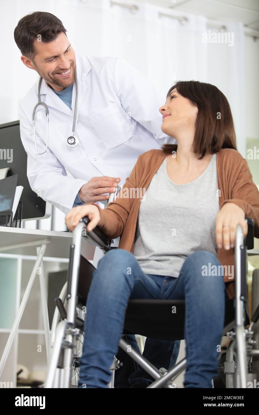 doctor pushing wheelchair and interacting with female patient Stock ...