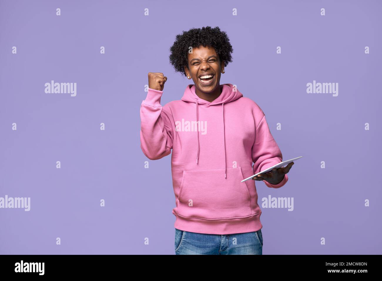 Happy African teenager winner student boy holding tablet celebrating ...