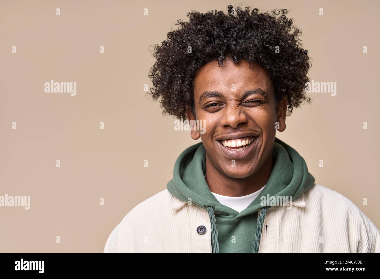 Happy African gen z guy winking isolated on beige background, closeup ...
