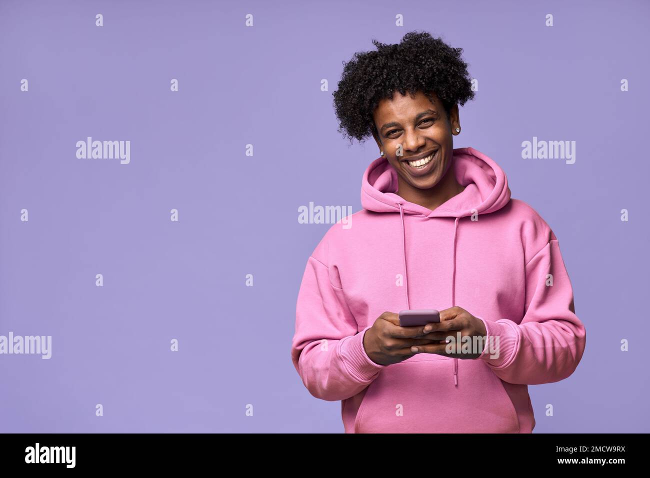 Happy African teen guy holding cellphone using mobile phone isolated on ...