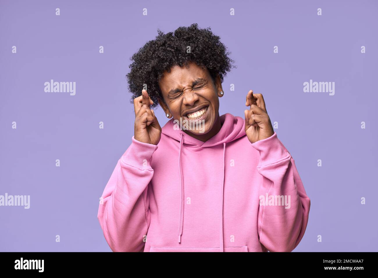 Happy African American teen guy crossing fingers making wish or feeling ...